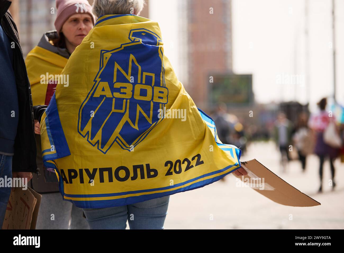 Ukrainian woman wearing a flag of Azov brigade on shoulders at a public ...