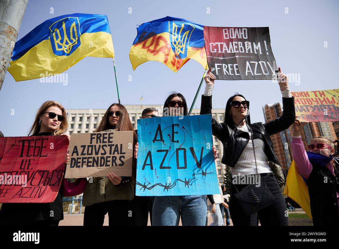 Ukrainian women posing with banners "Free Azov" and national flags of ...