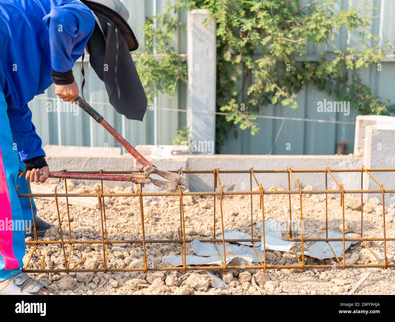 Worker is cutting reinforcement rebar steel work with bolt cutters at ...