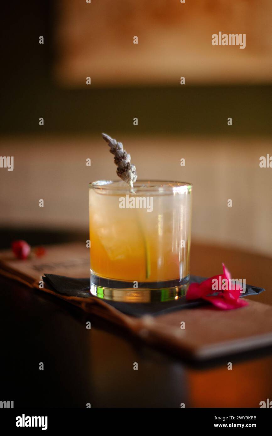 Cocktail with garnish sitting on bar top Stock Photo - Alamy
