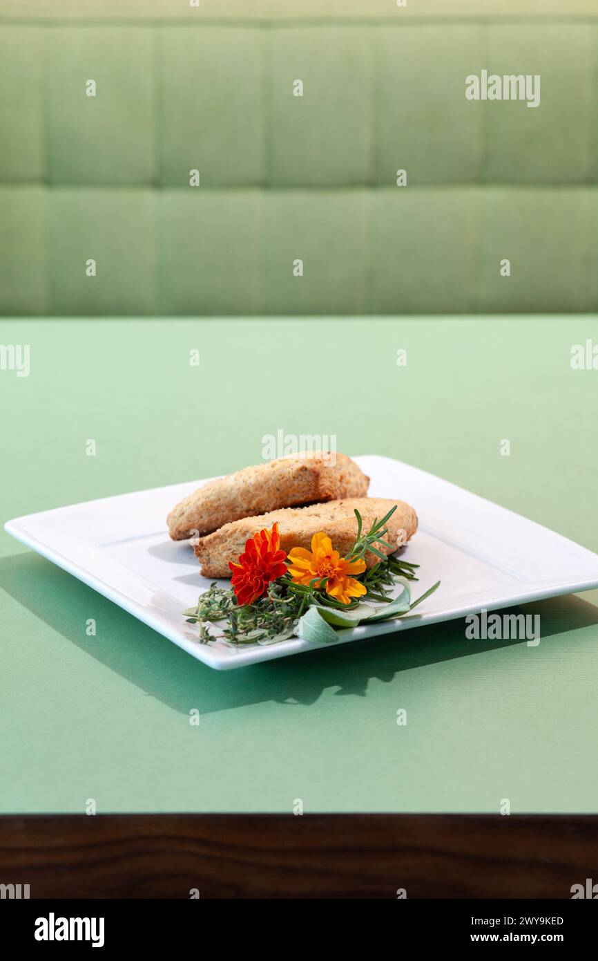 Pastries on a plate green table and green booth backdrop Stock Photo ...