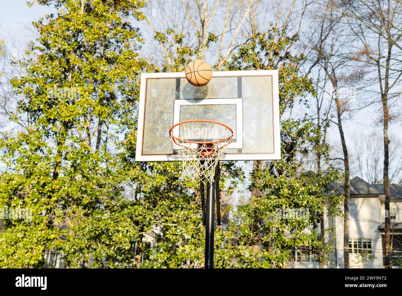 Outdoor basketball hoop with ball in air Stock Photo - Alamy