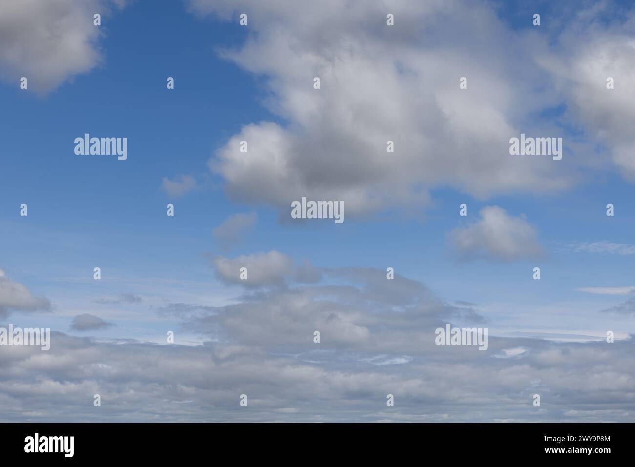 Expansive blue sky punctuated by soft, puffy clouds, creating an ideal ...