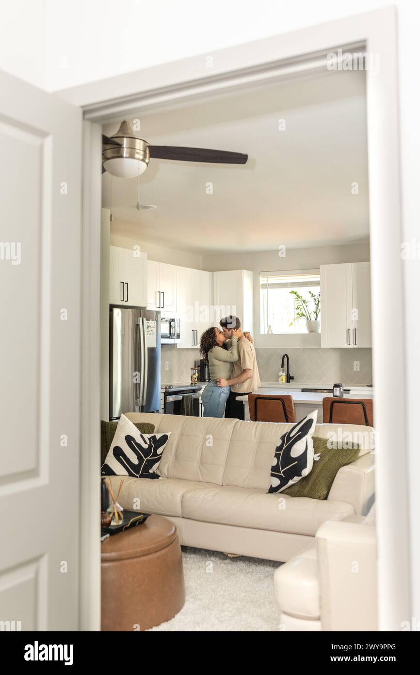 A couple shares a warm embrace in the kitchen Stock Photo - Alamy