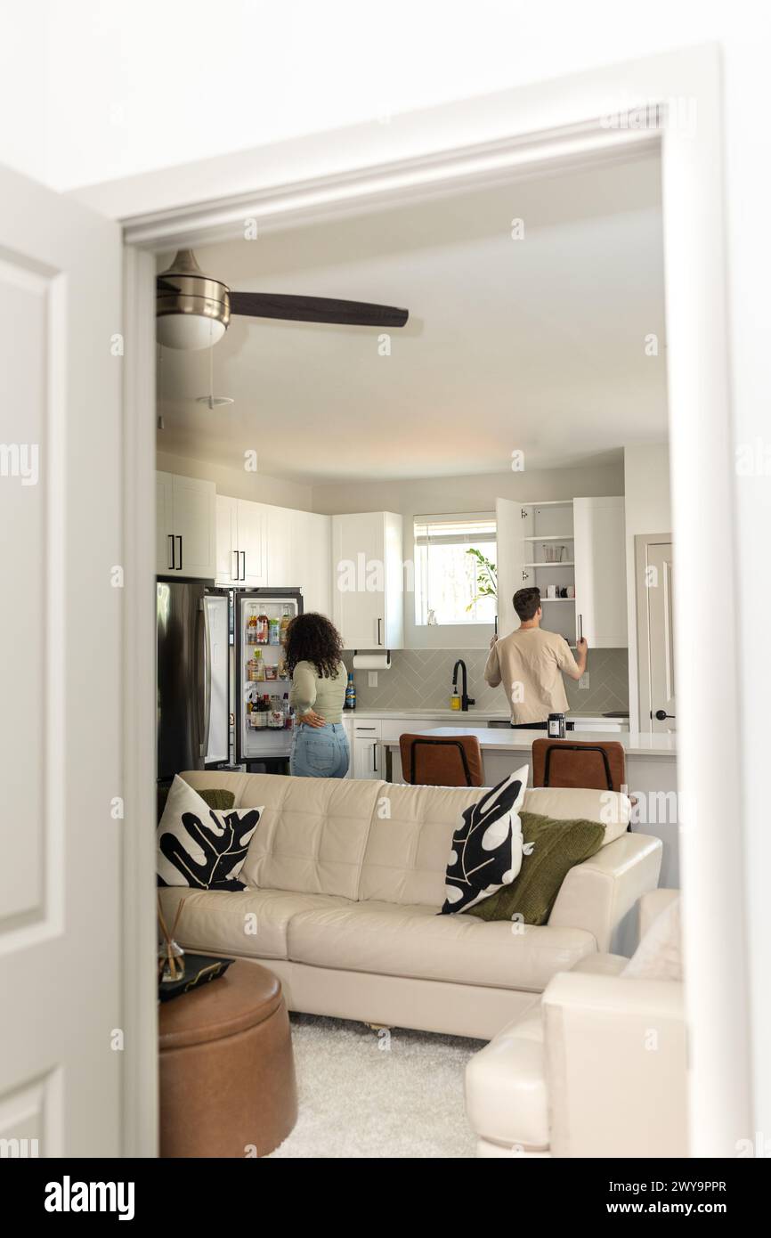 Couple in their organized kitchen, engaged in routine tasks Stock Photo ...