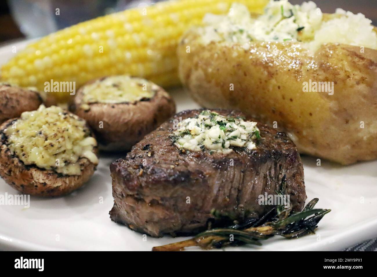 Seared filet mignon steak plated with classic sides Stock Photo - Alamy
