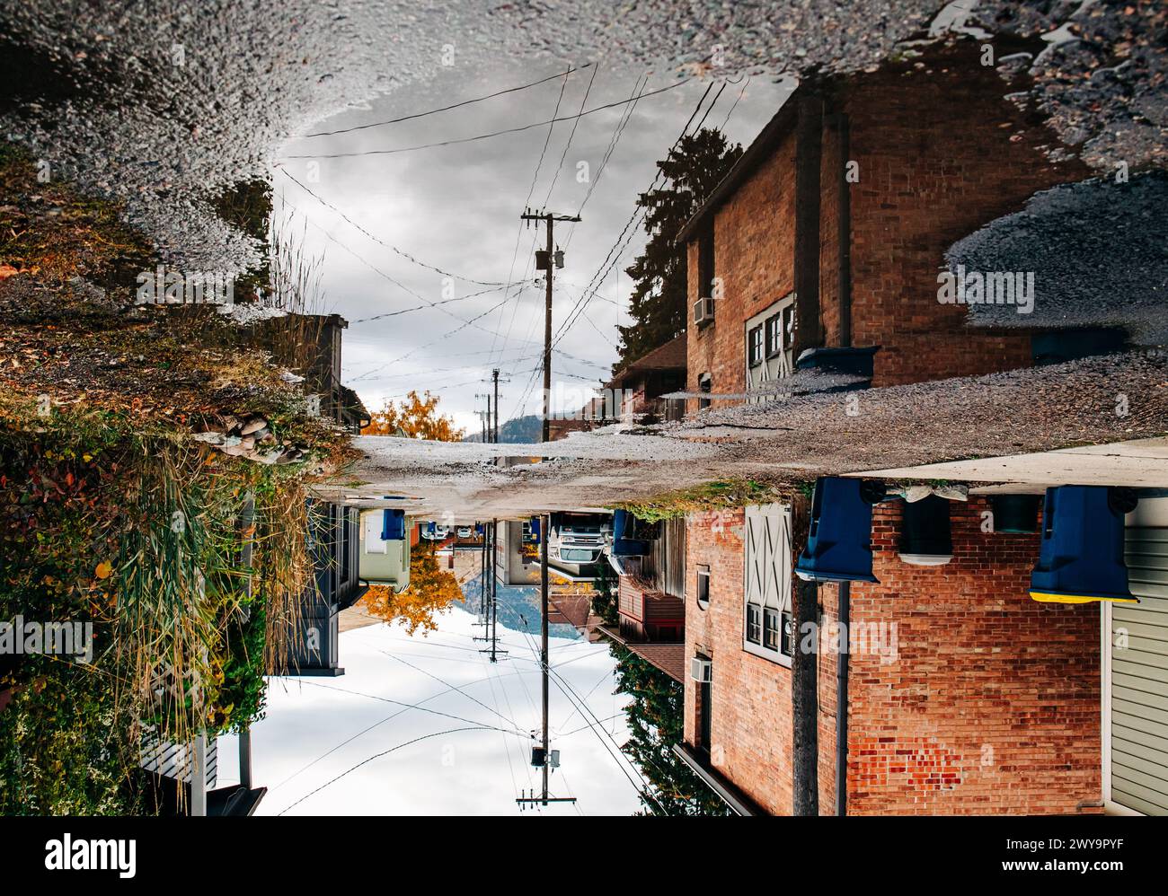 Street scene with alley reflected in large puddle Stock Photo - Alamy