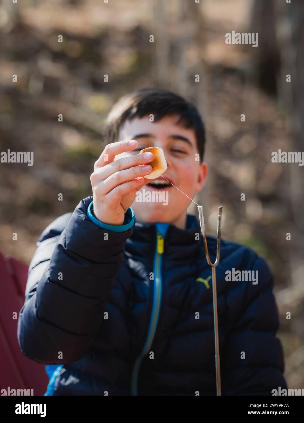 Happy boy toasting a marshmallow outside on a spring day Stock Photo ...