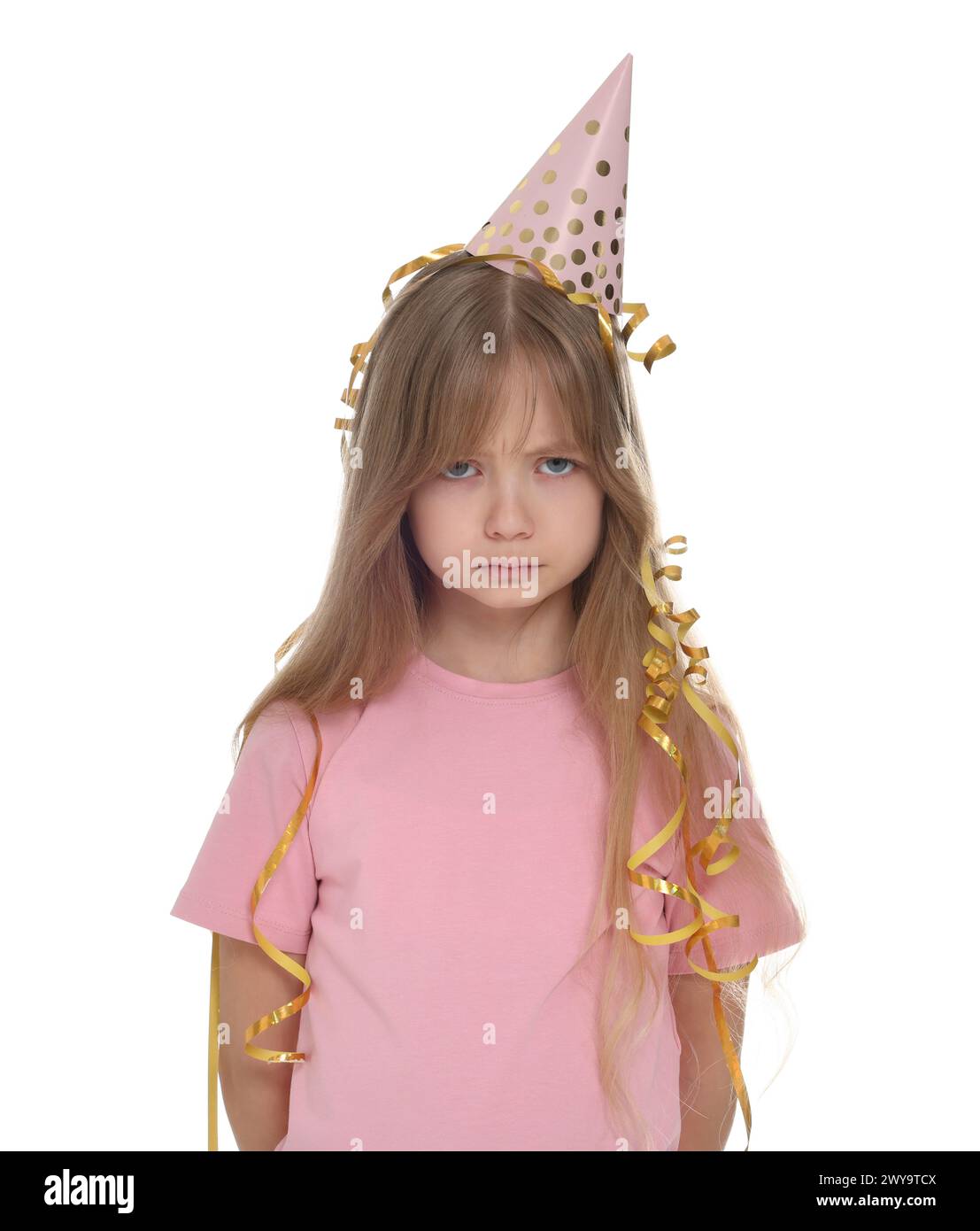 Unhappy little girl in party hat on white background Stock Photo - Alamy
