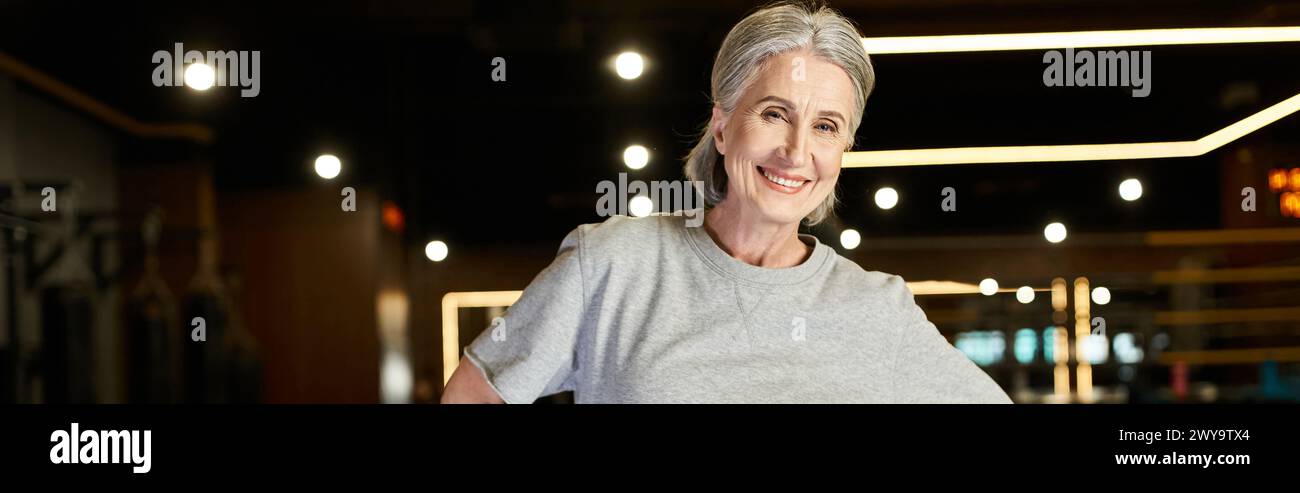 pretty mature jolly woman in cozy sportswear posing with arms akimbo ...