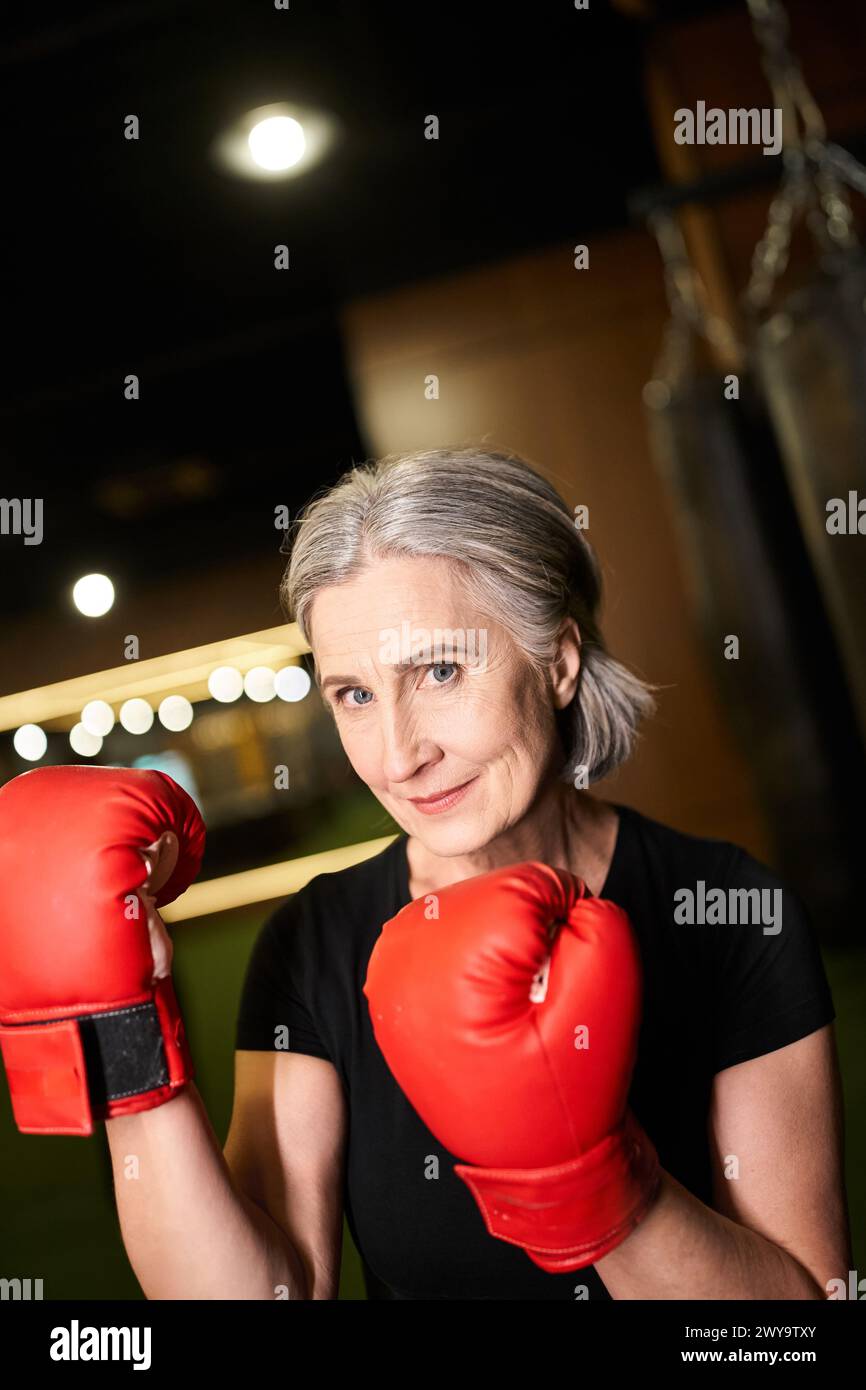 attractive senior merry woman in sportswear with gray hair posing with ...