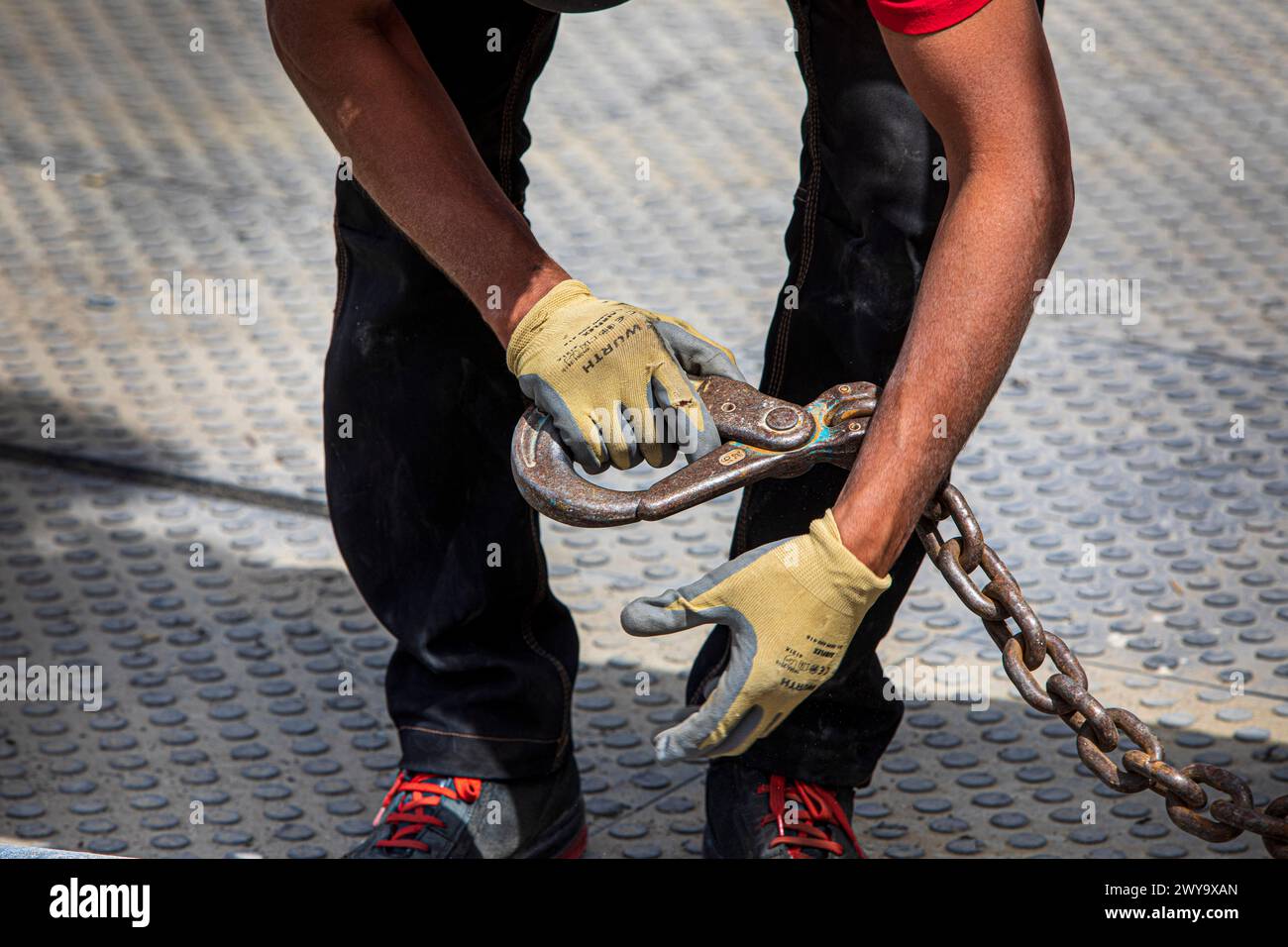 Building site, worker handling a crane lifting hook Stock Photo - Alamy