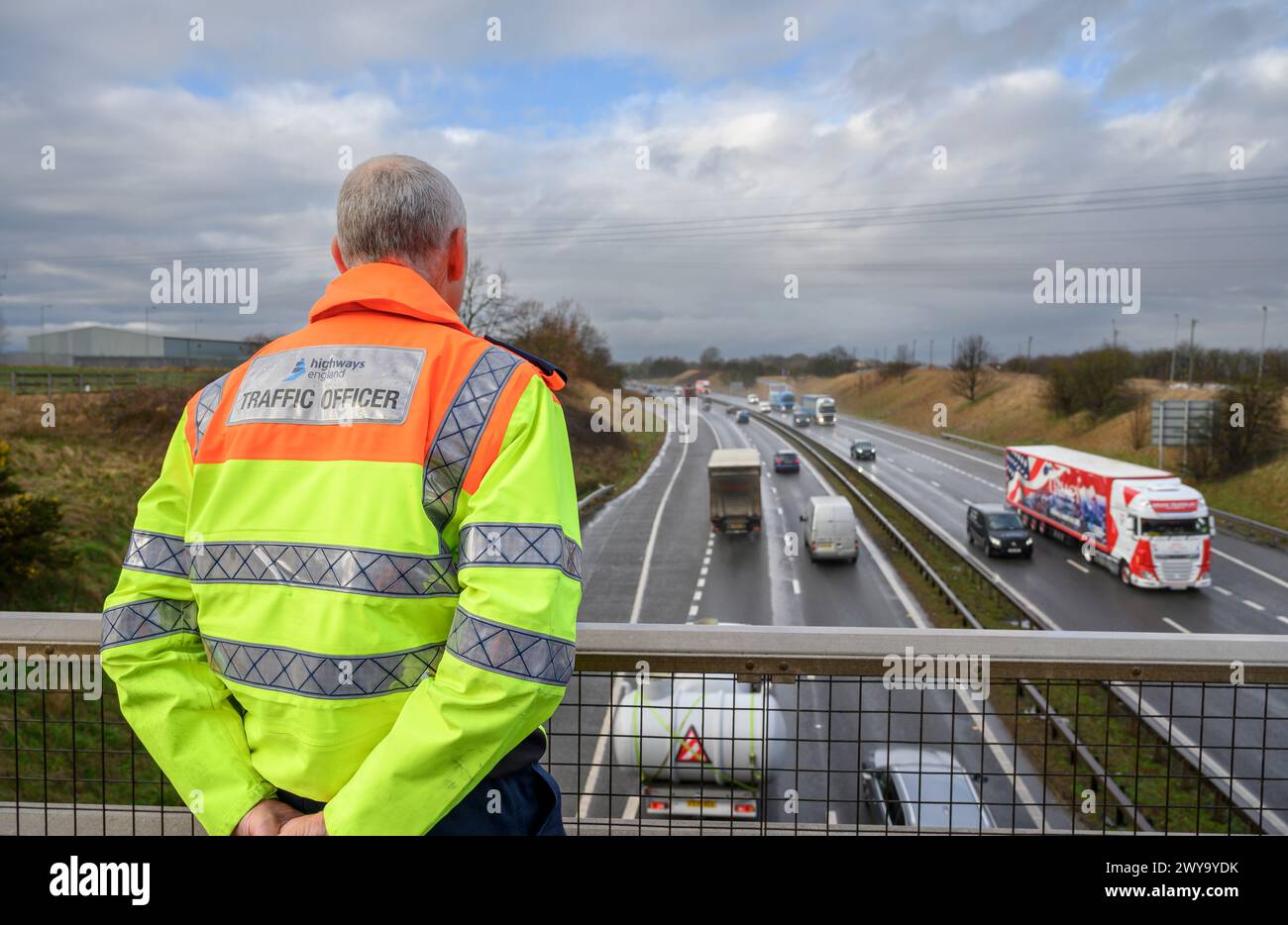 Highways England traffic officer observing traffic flow from a bridge ...