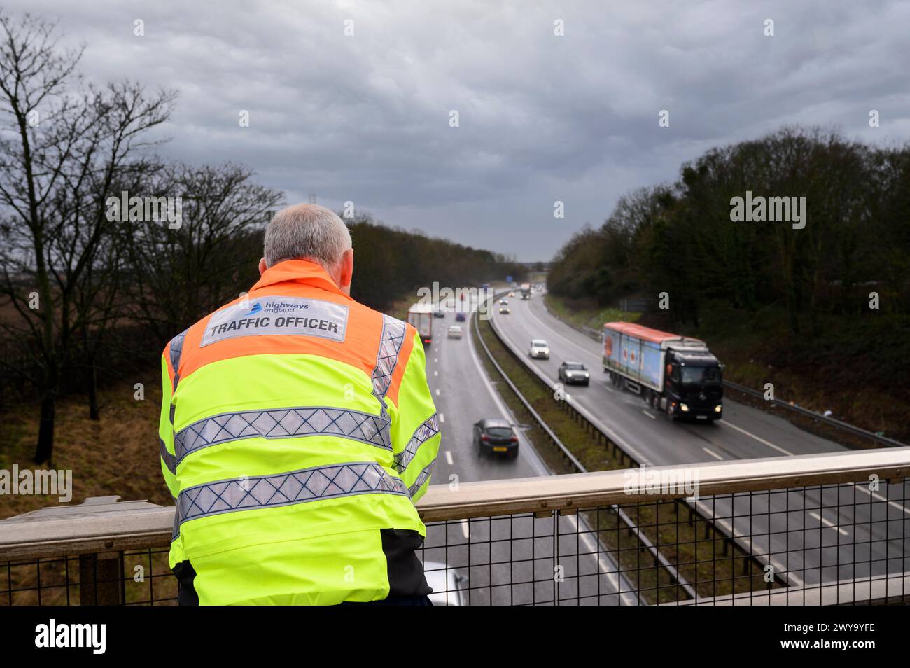 Highways England traffic officer observing traffic flow from a bridge ...