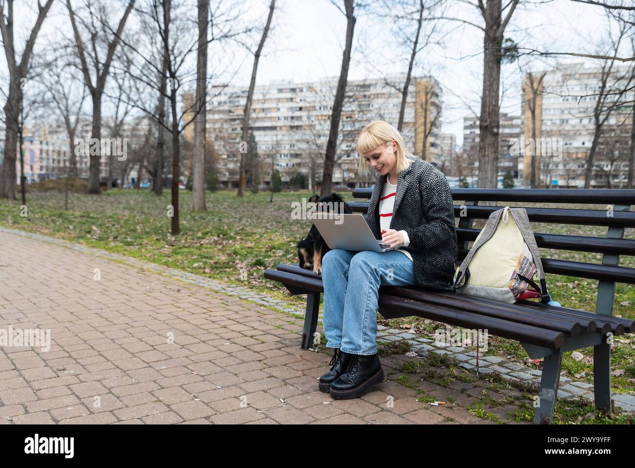 Young successful hipster businesswoman generation Z sitting on park ...