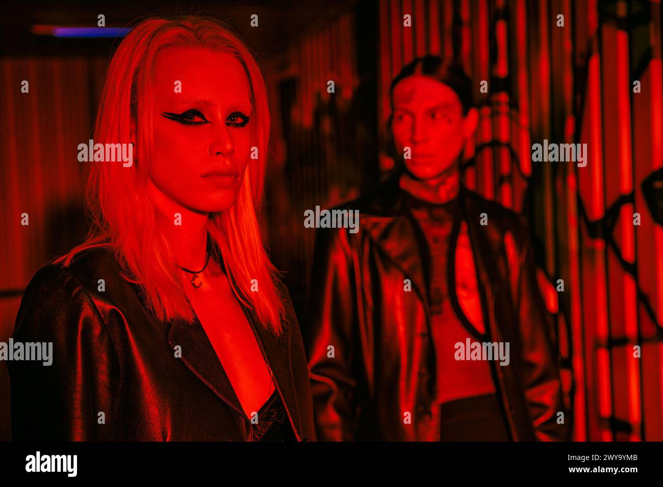 Couple standing together under red lighting Stock Photo - Alamy