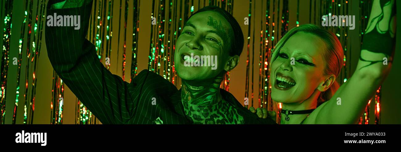 A couple standing up, enjoying the lively atmosphere of a rave party or ...