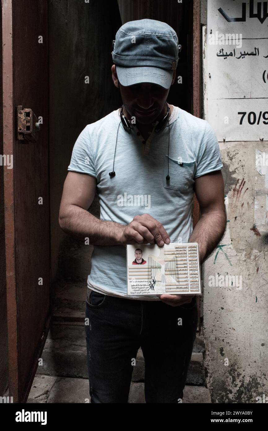 A Palestinian refugee displays his refugee ID, rendered useless in ...