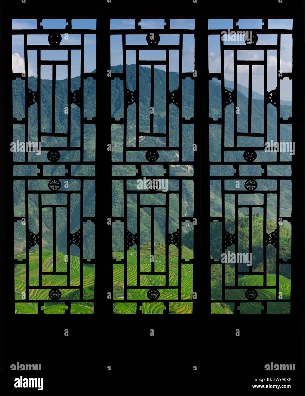 View through a fretwork screen panel of rice fields, Dragons Backbone ...