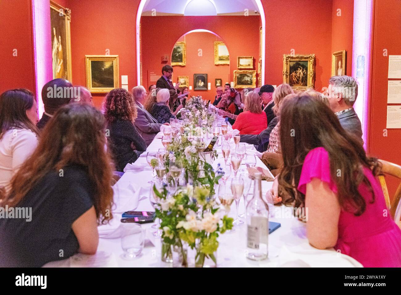 Wedding guests sat a dinner table during a speech at a wedding at ...