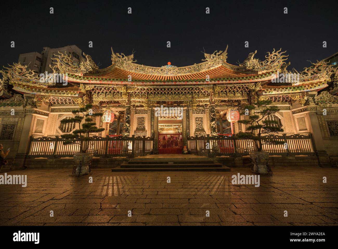 An intricately decorated Longshan temple at night filled with flowers ...