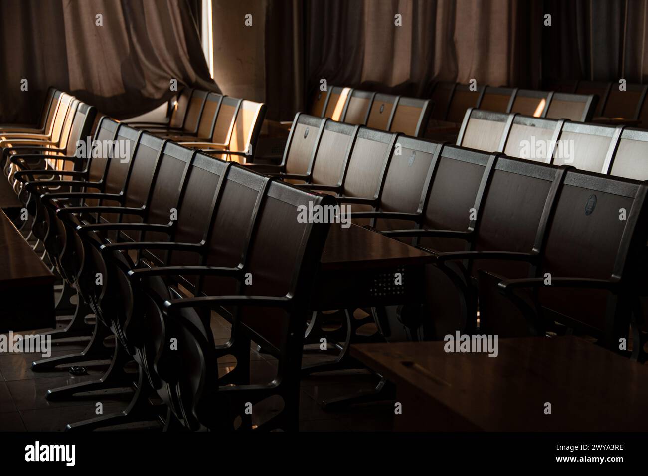 The rows of black chairs in an auditorium facing the front at Wuhan ...