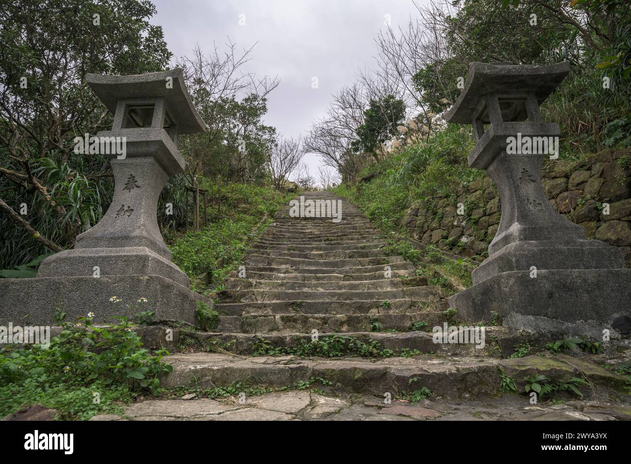 An old stone staircase flanked by traditional lanterns leading through ...