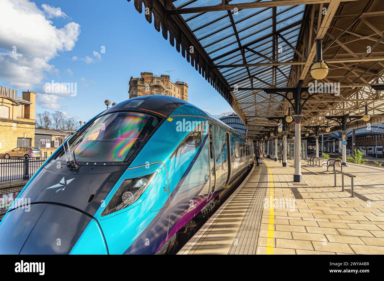 A train stands at a platform under a 19th Century historic canopy ...