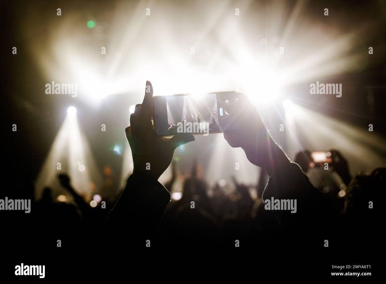 Filming a concert with a mobile phone, music and light show on stage ...