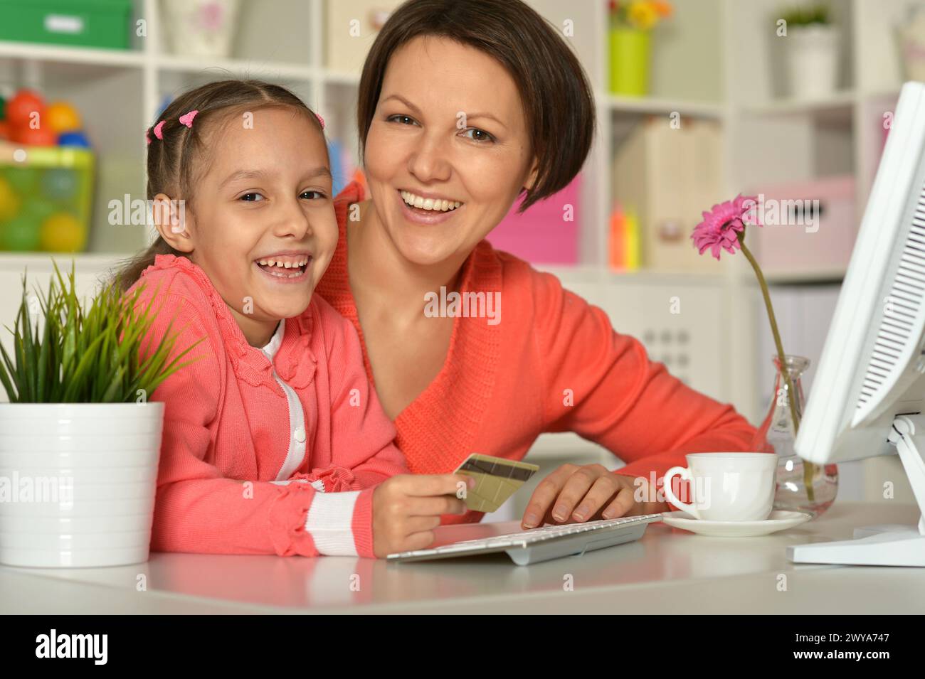 Smiling mother and daughter using computer for online shopping Stock ...