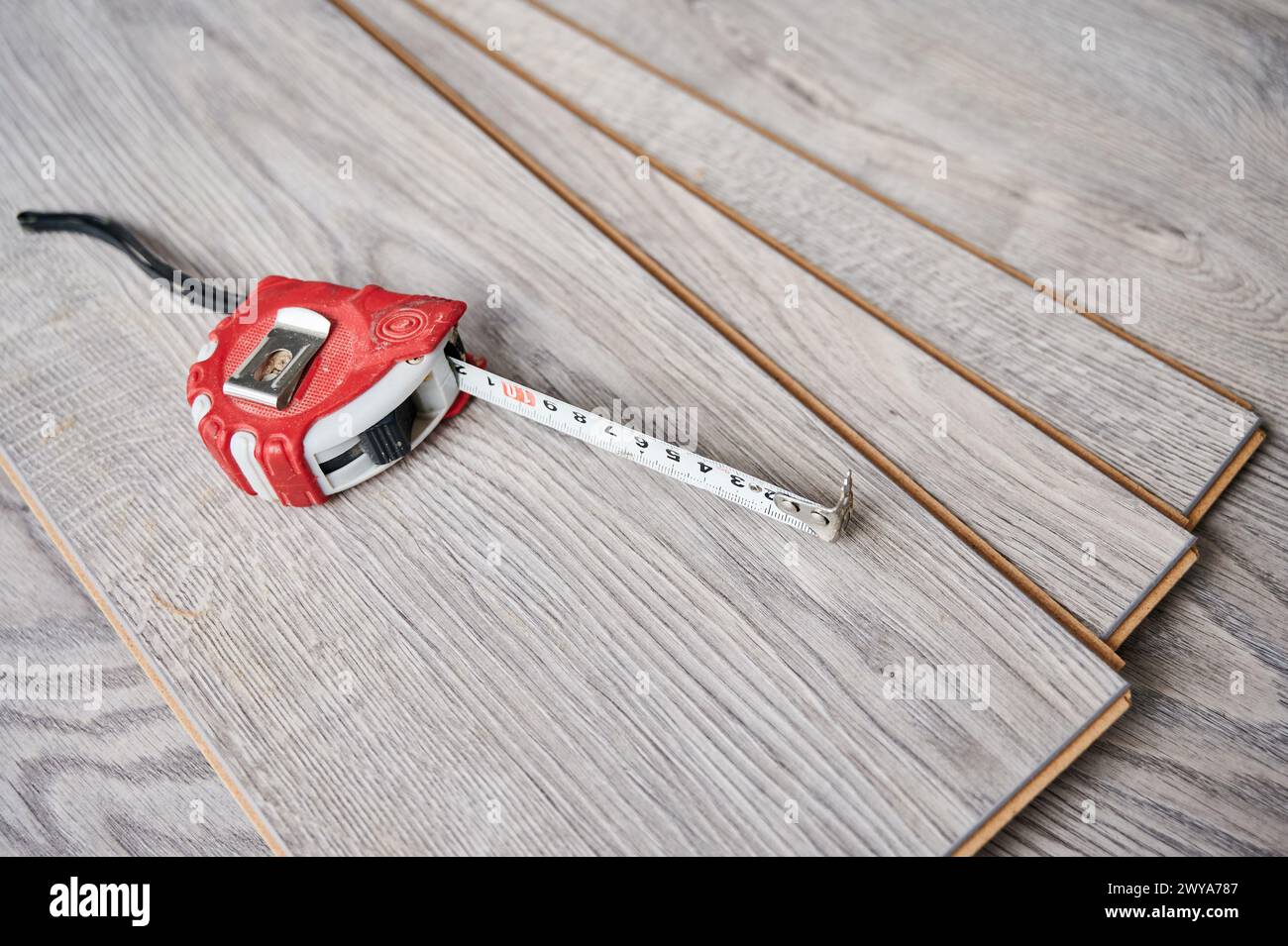 Measuring tape on wooden flooring planks for home renovation ...