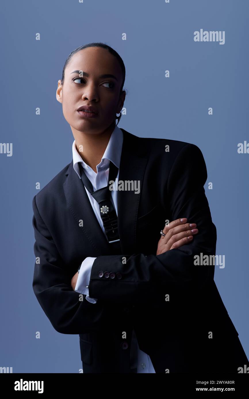A young African American woman confidently poses in a suit and tie in a ...