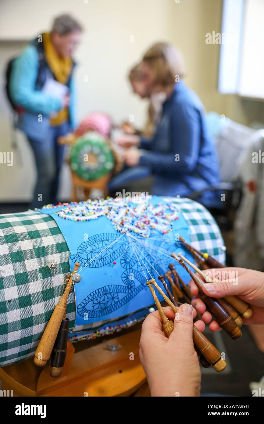 05 April 2024, Saxony, Schwarzenberg: Three women making bobbin lace ...