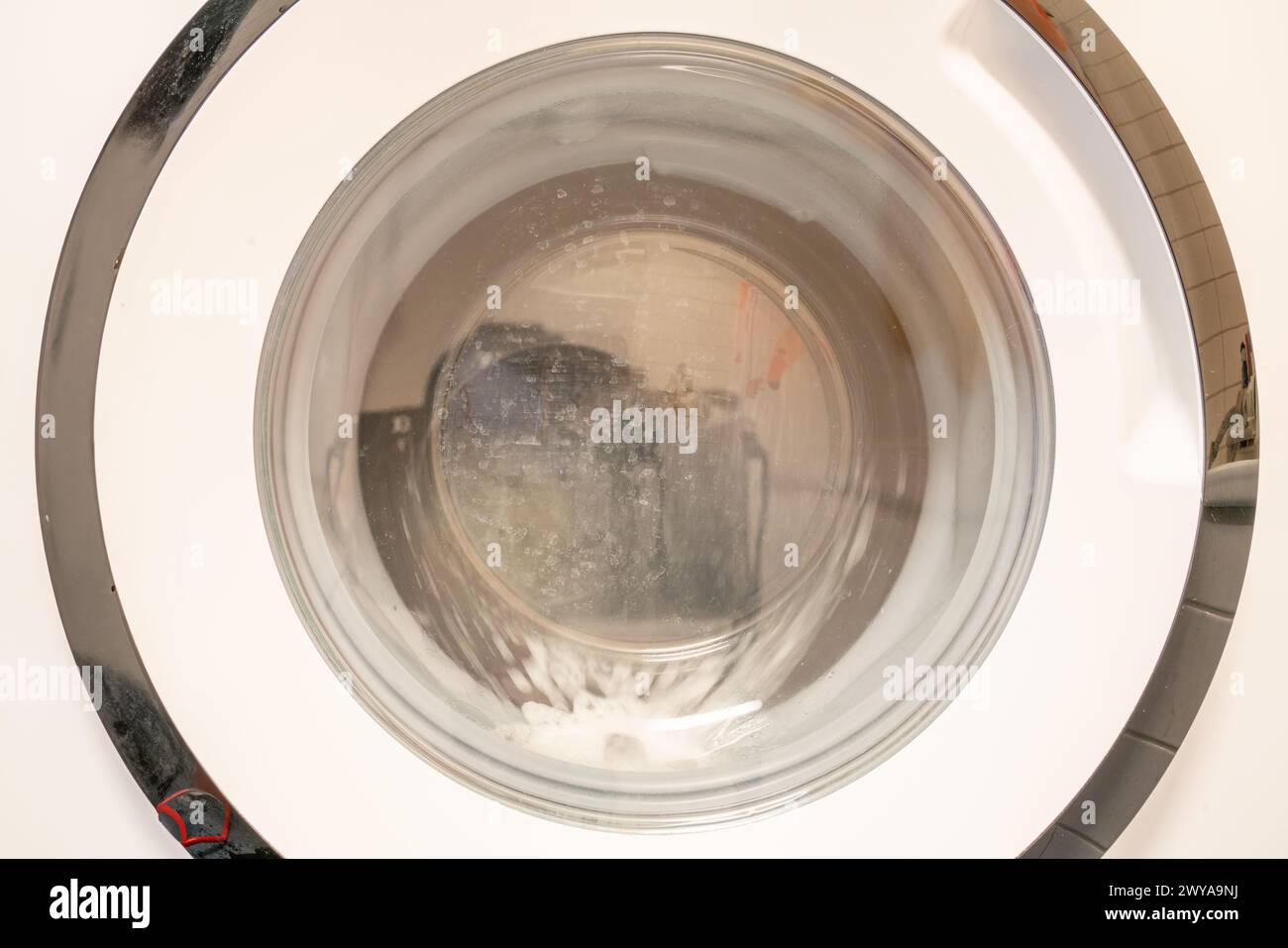 Front view of running washing machine showing distorted foam in turning ...