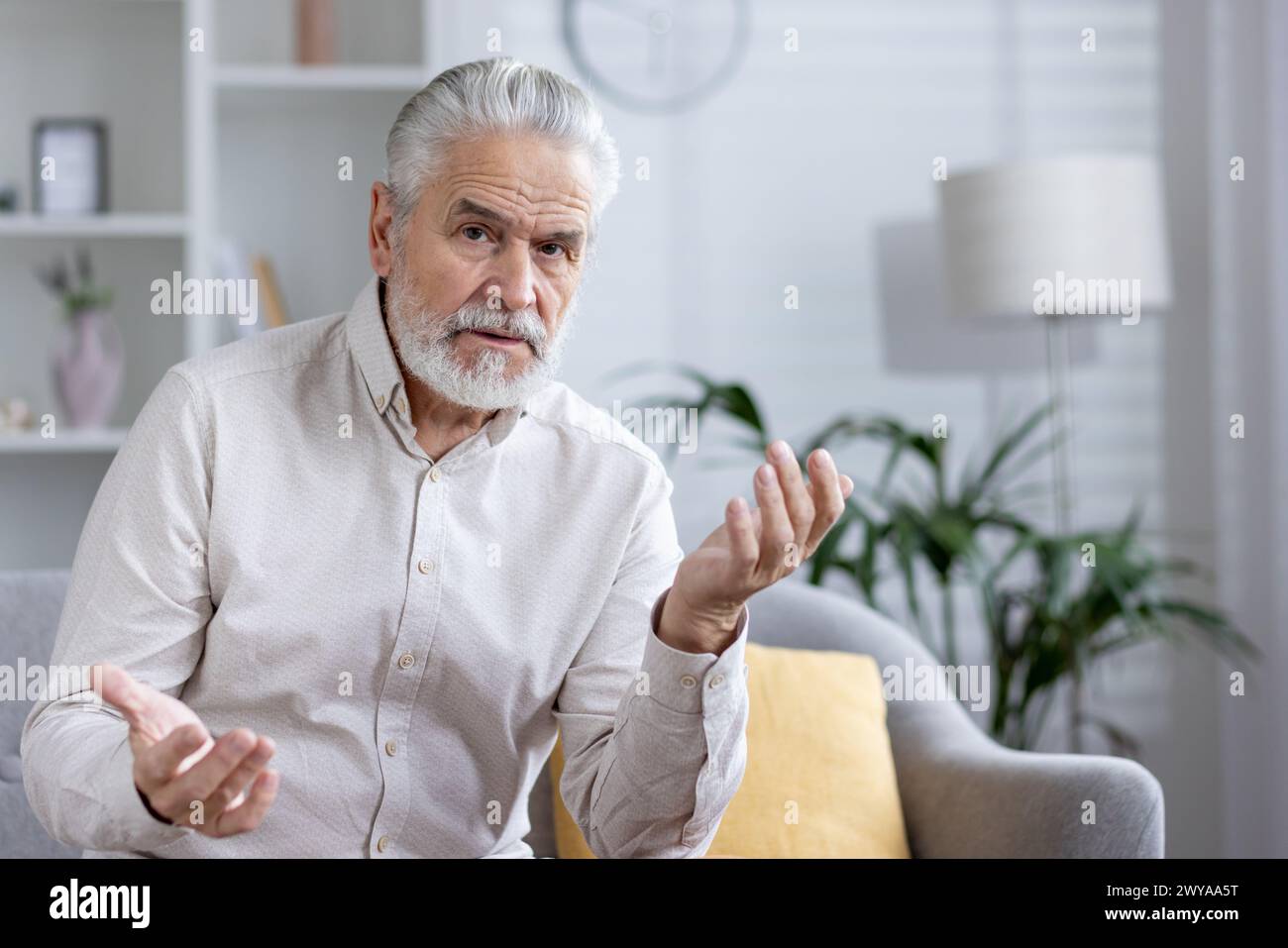 Elderly gentleman engages in a telehealth consultation, speaking to a ...