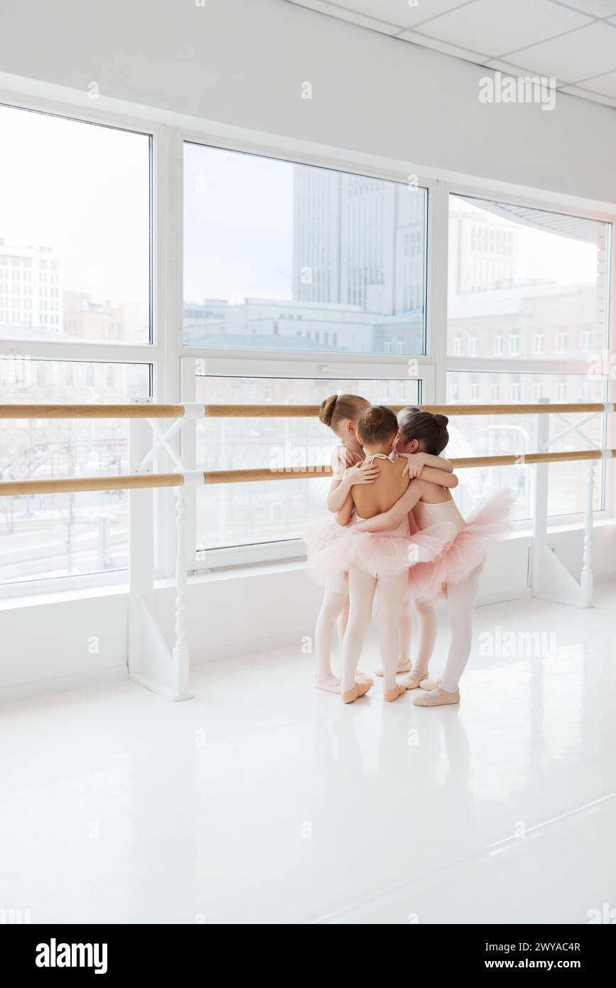Cute little girls, ballerinas hugs in group while training near barre ...