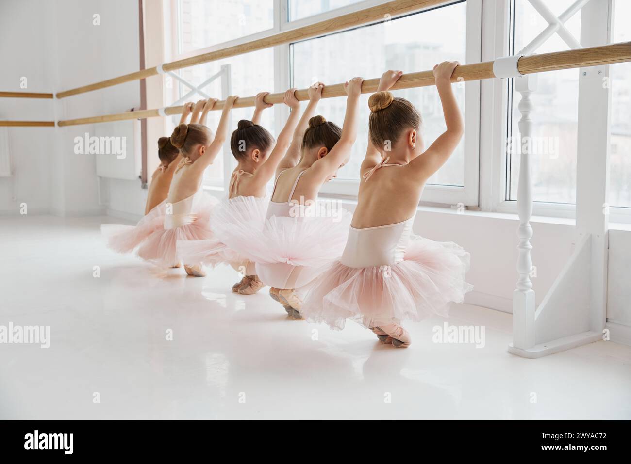 Little girls, ballerinas in class practicing coordinated barre ...