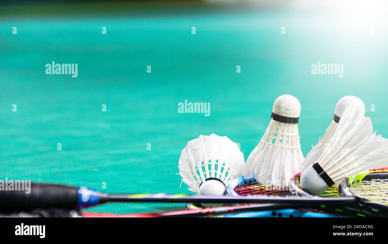 White badminton shuttlecocks and badminton rackets on green floor ...