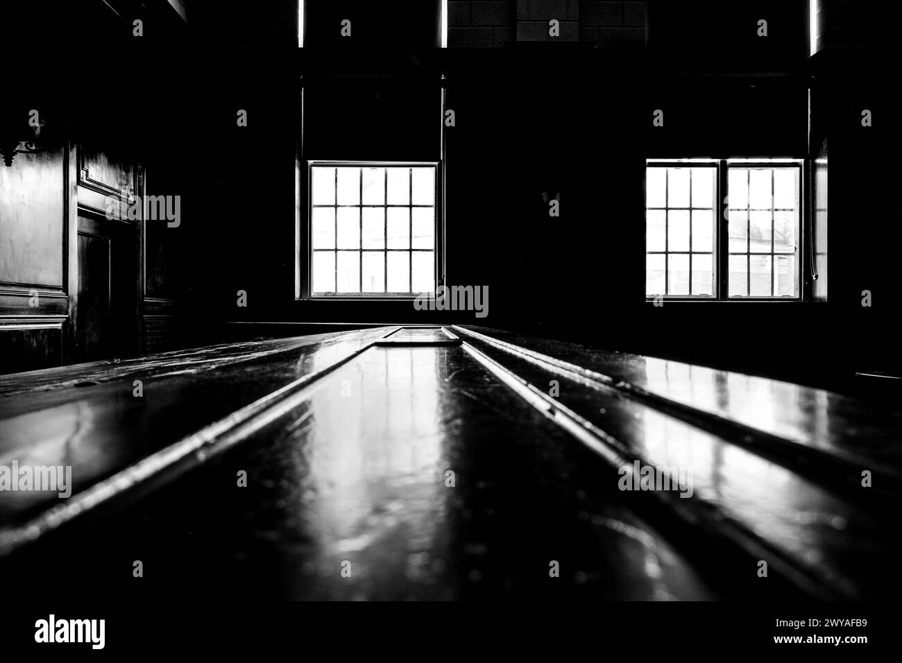 Judge's bench with sunlight pouring through windows into unlit room ...