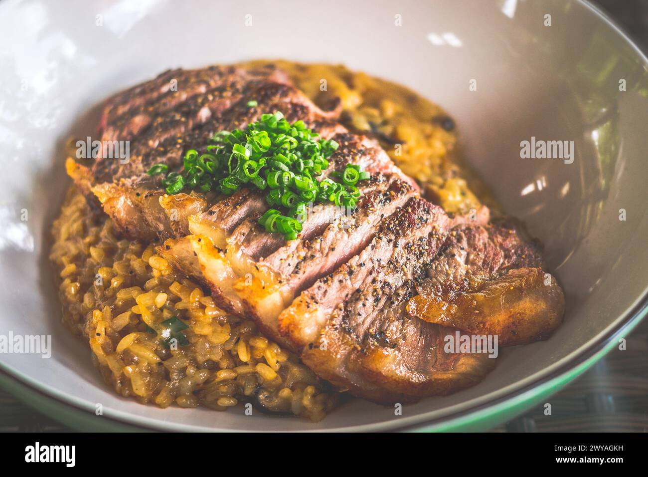 Risotto served with angus medium rare ribeye steak in a bowl Stock ...