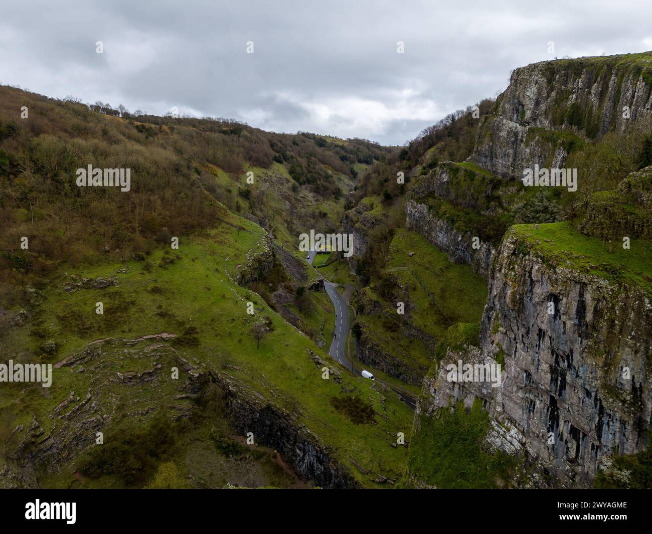 Aerial view of a verdant limestone gorge split by a serpentine road ...