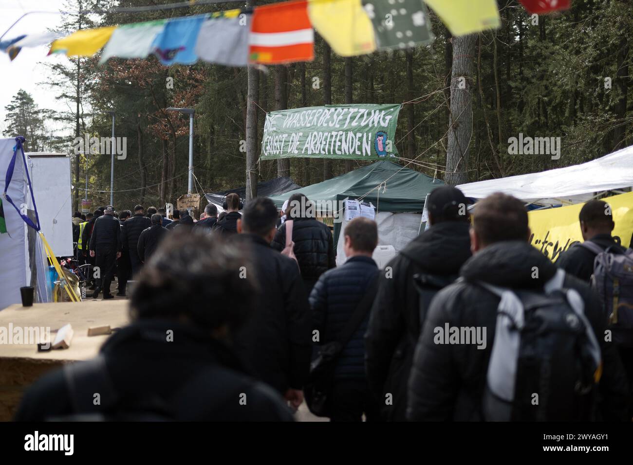 05 April 2024, Brandenburg, Grünheide: Tesla employees walk past a ...