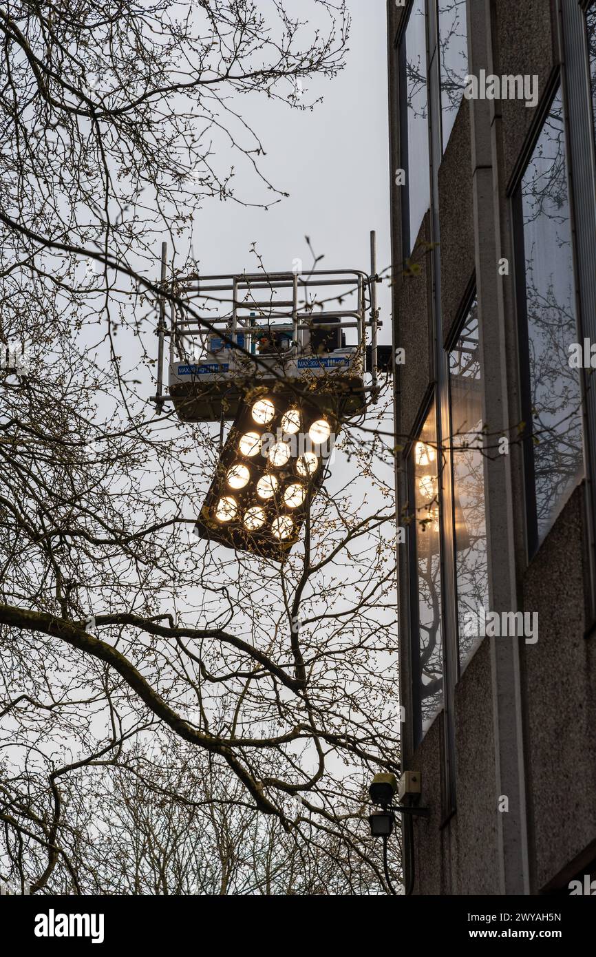 Suspended scaffolding platform alongside a city building for window ...