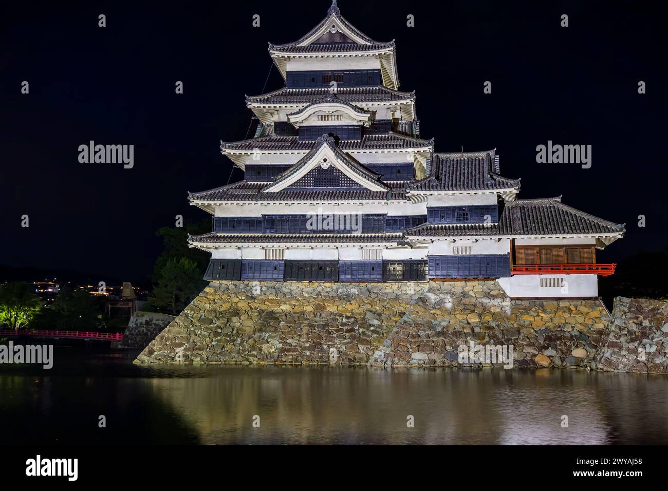 Ancient Japanese Matsumoto Castle at night with a reflection in the ...