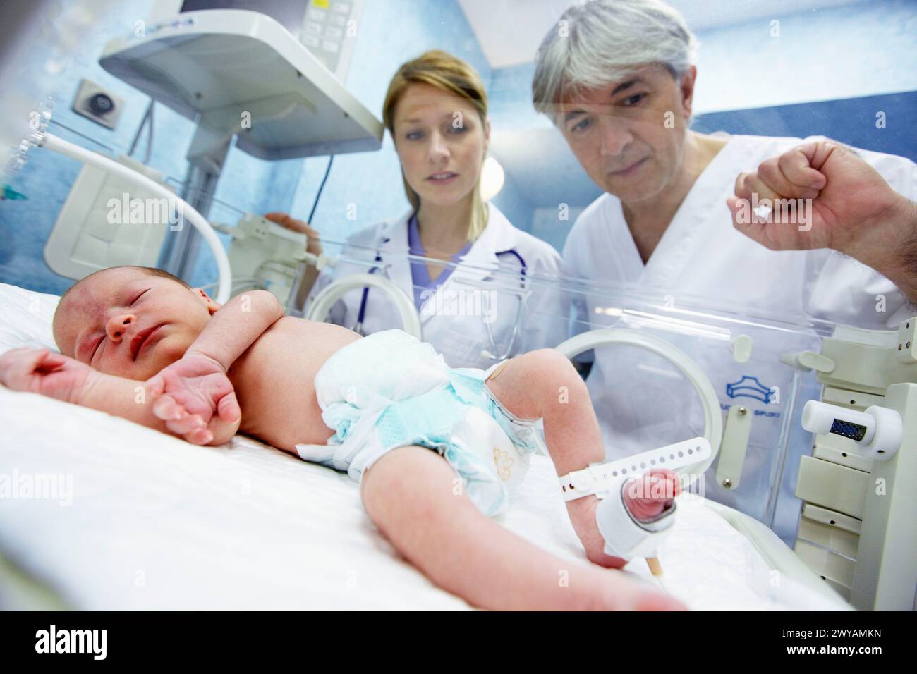 Pediatricians with newborn baby in incubator, pediatrics. Hospital ...