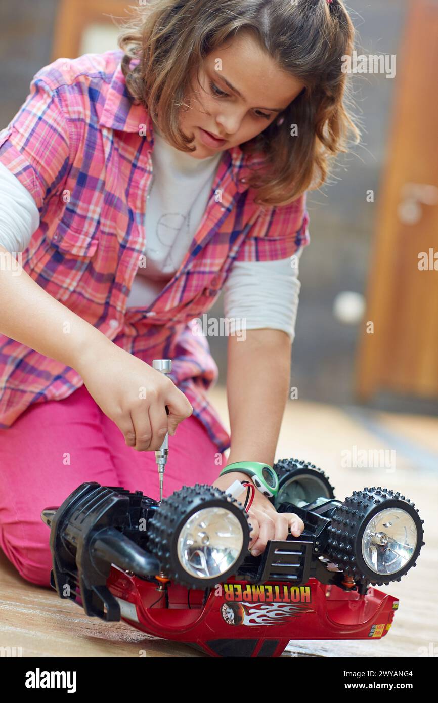Girl with a screwdriver fixing a toy. DIY Stock Photo - Alamy
