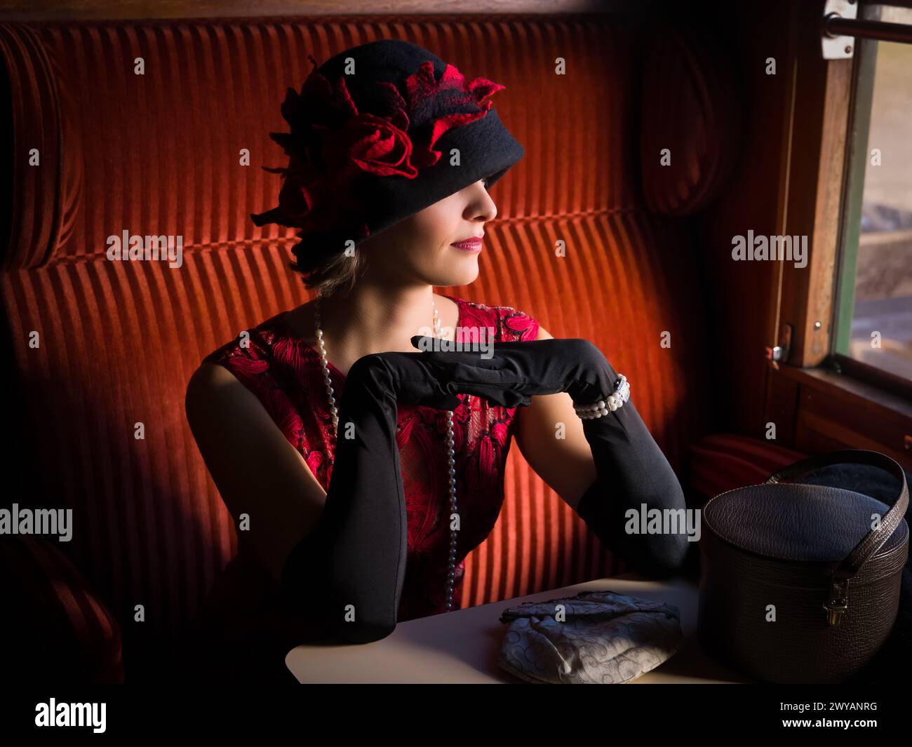 Attractive 1920s woman in red flapper dress and cloche hat posing in ...