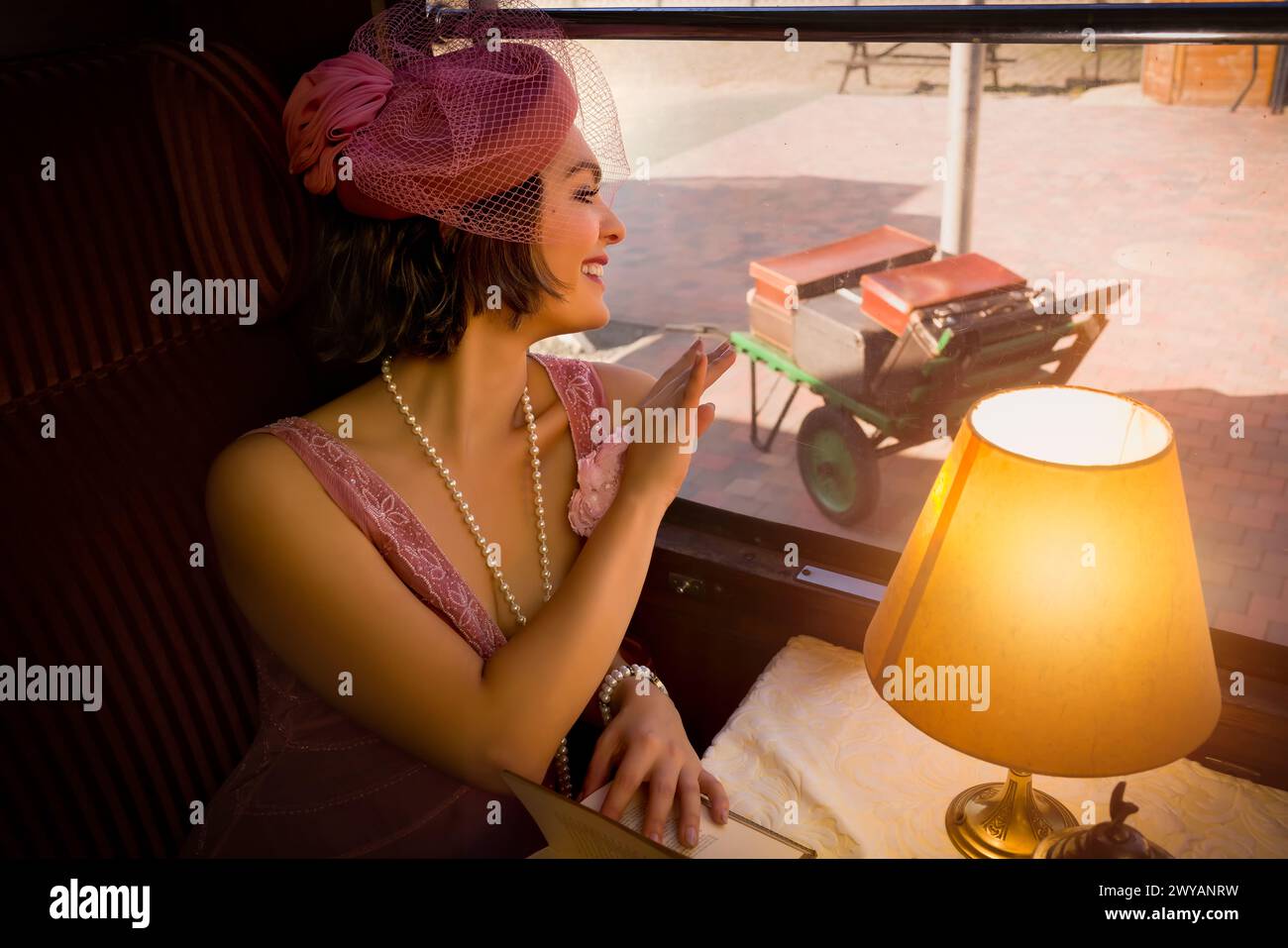 Reenactment scene of a 1920s flapper dress lady enjoying high tea in an ...