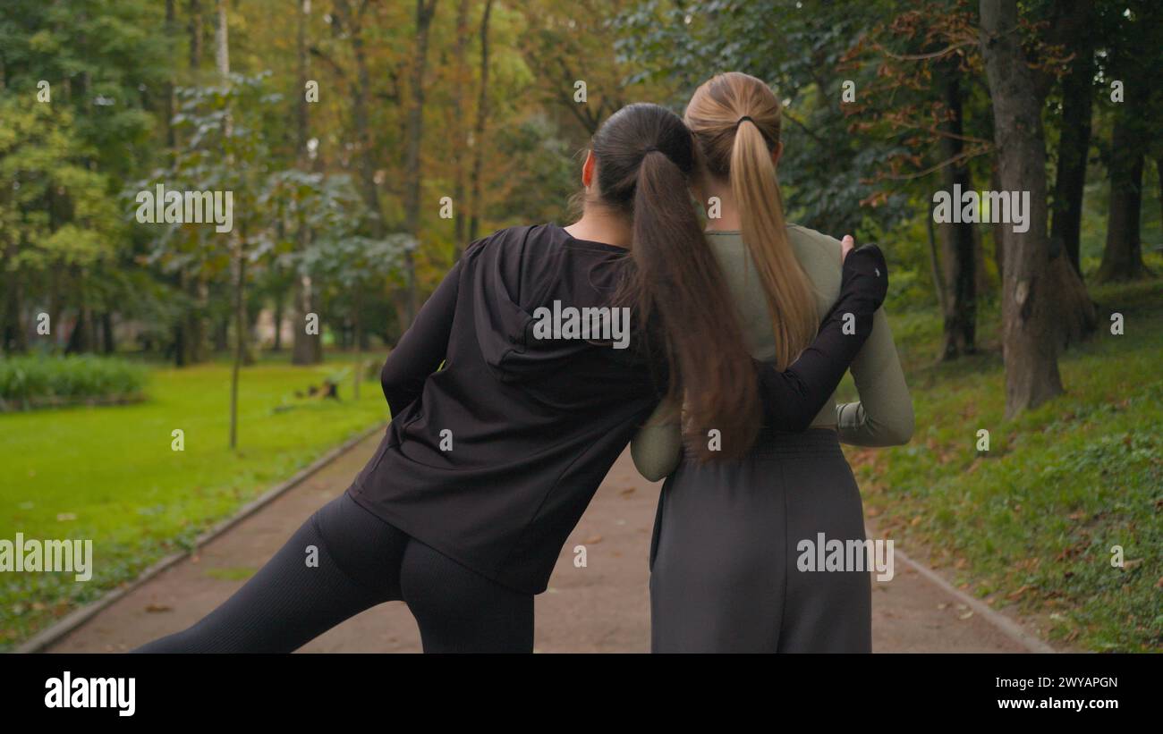 Back view two unrecognizable sport girls women ladies friends in sporty ...