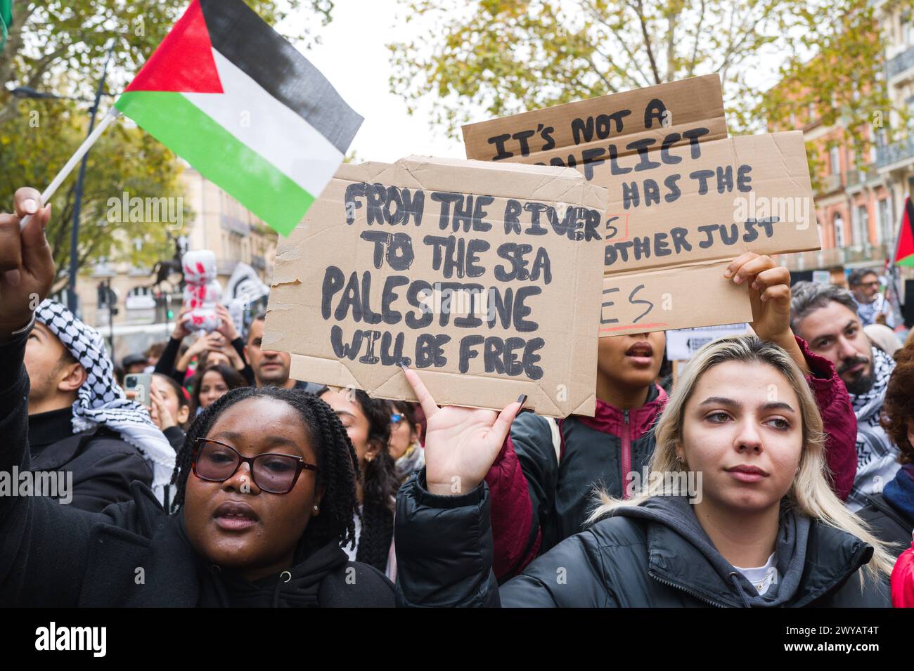 A young woman with a placard, From the river to the sea Palestine will ...